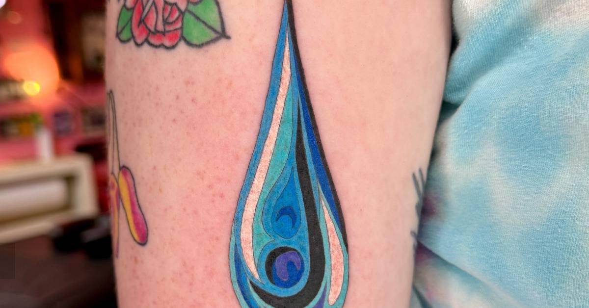 Waterdrop tattoo located on the upper arm, done in