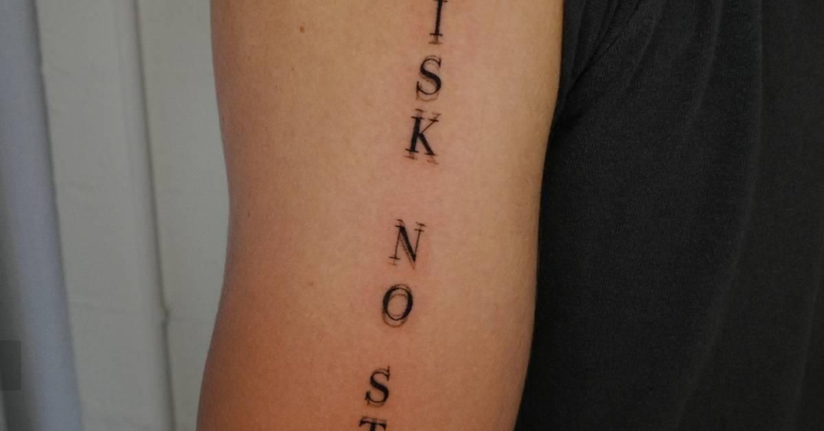 "No risk, no story" blurry lettering tattoo located on