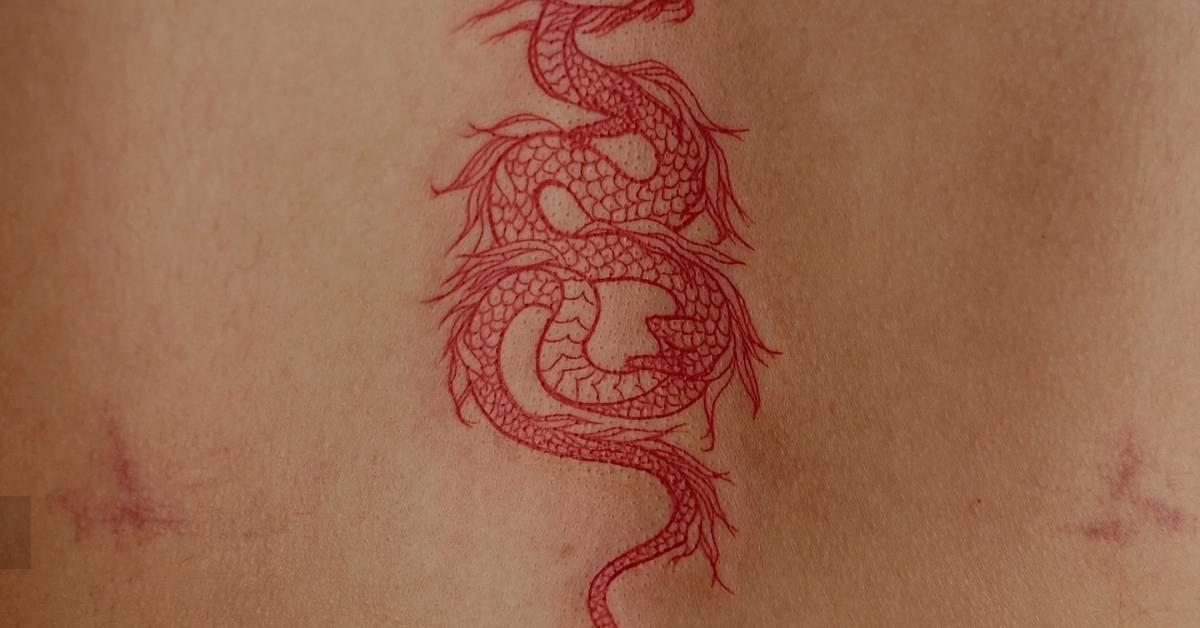 Red dragon tattoo in fine line style located on the