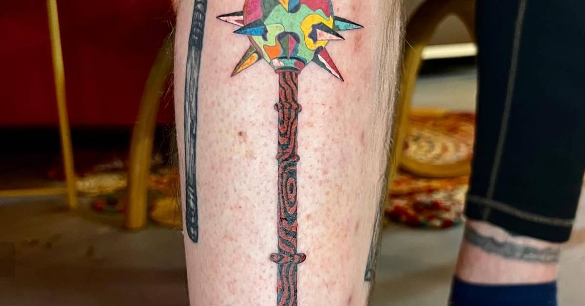 Large mace tattoo located on the shin, illustrative