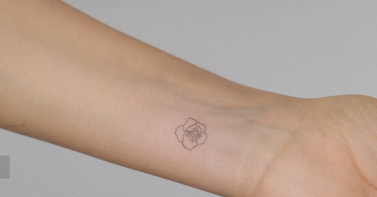 Fine line style rose head tattoo placed on the wrist.