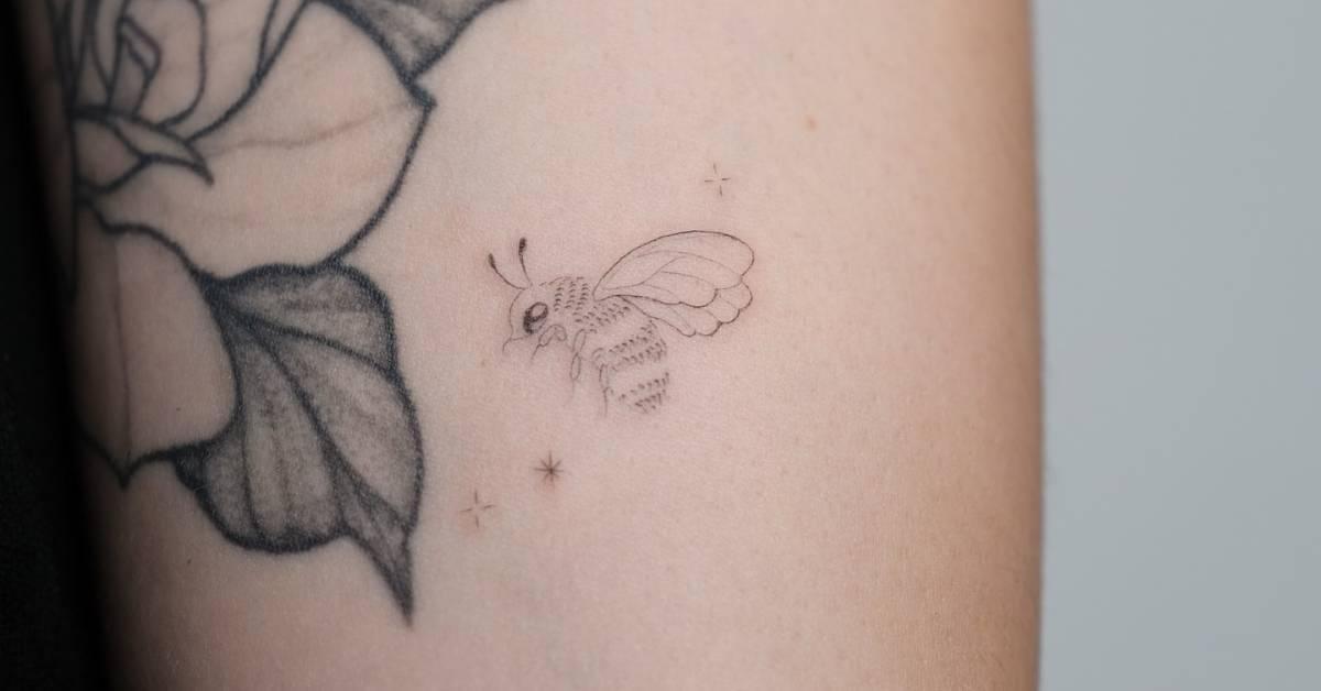 Little bee tattoo in fine line style located on the