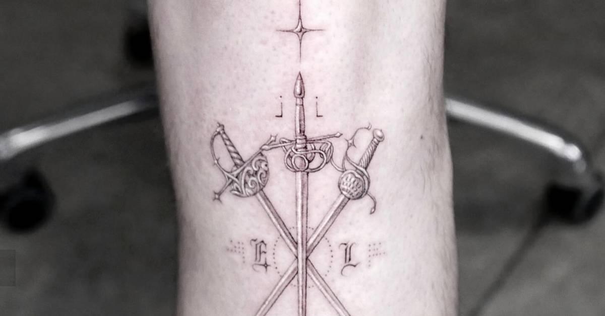 Rapiers and initials tattoo located on the knee.