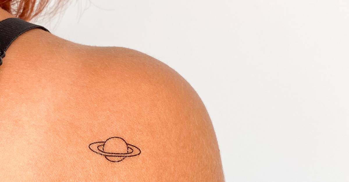 Fine line style Saturn temporary tattoo placed on the