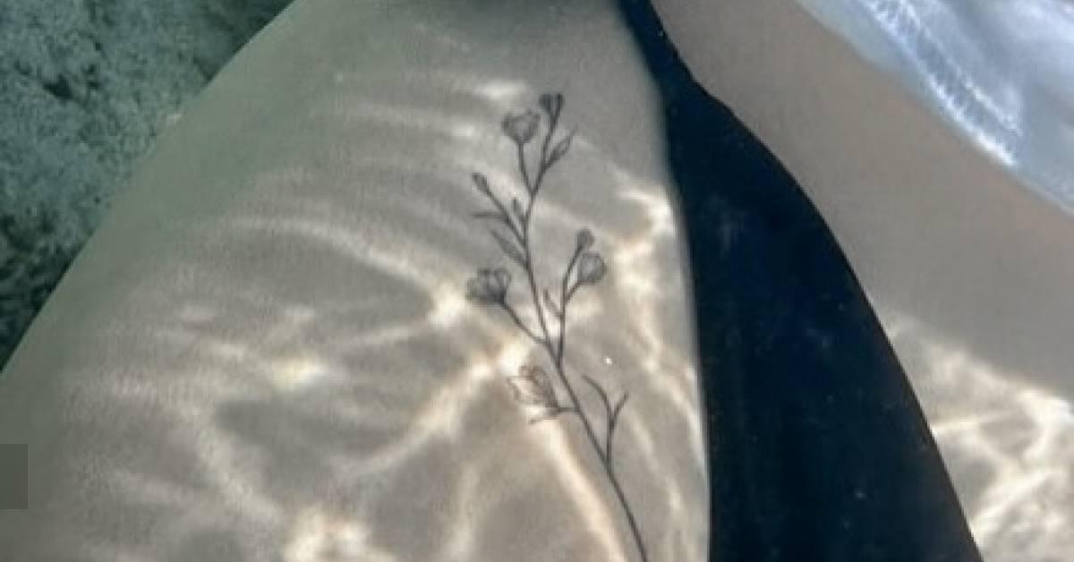 Healed fine line flowers tattoo located on the pelvis.