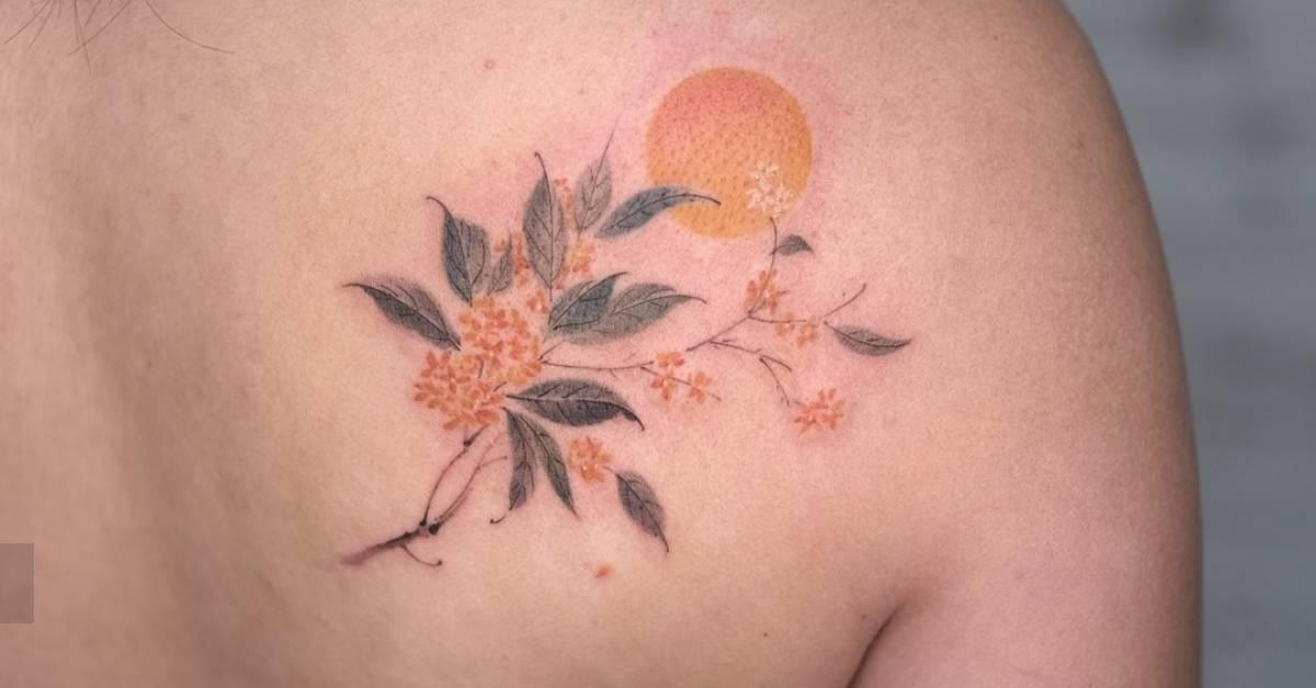Flower branch tattoo placed on the shoulder blade,