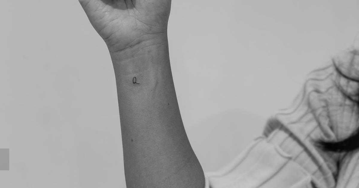Minimalistic style letter "Q" tattoo placed on the