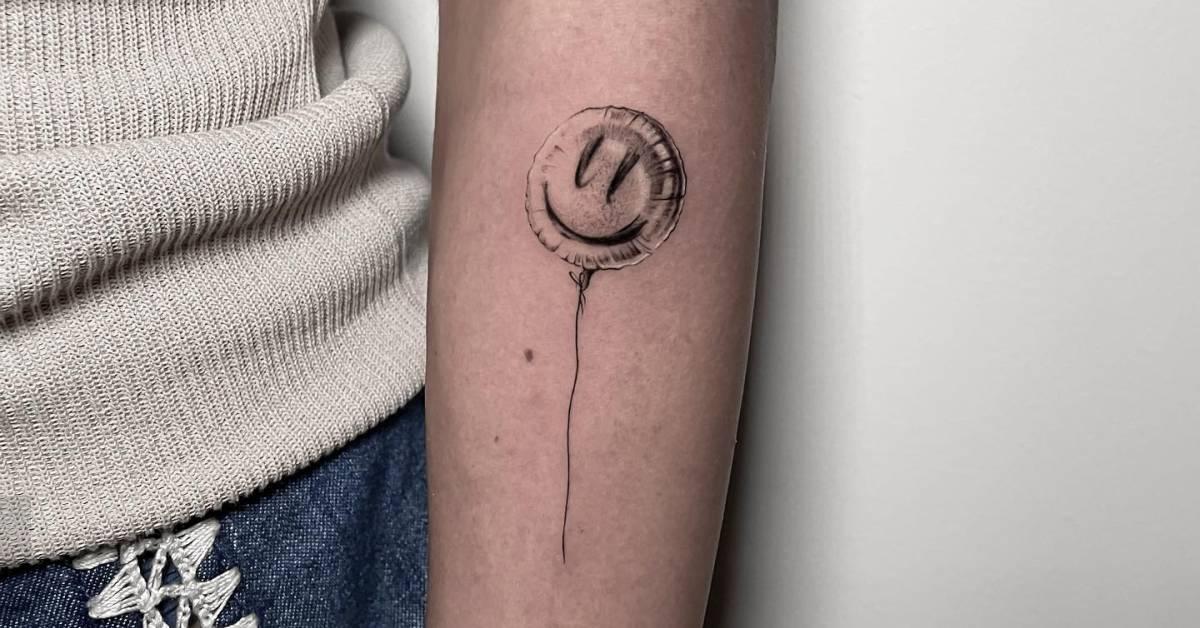 Micro-realistic style smiley face balloon tattoo