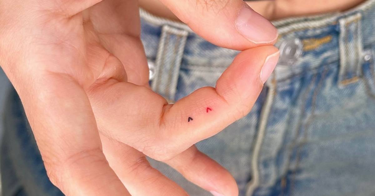 Tiny micro hearts tattooed on the finger, minimalistic