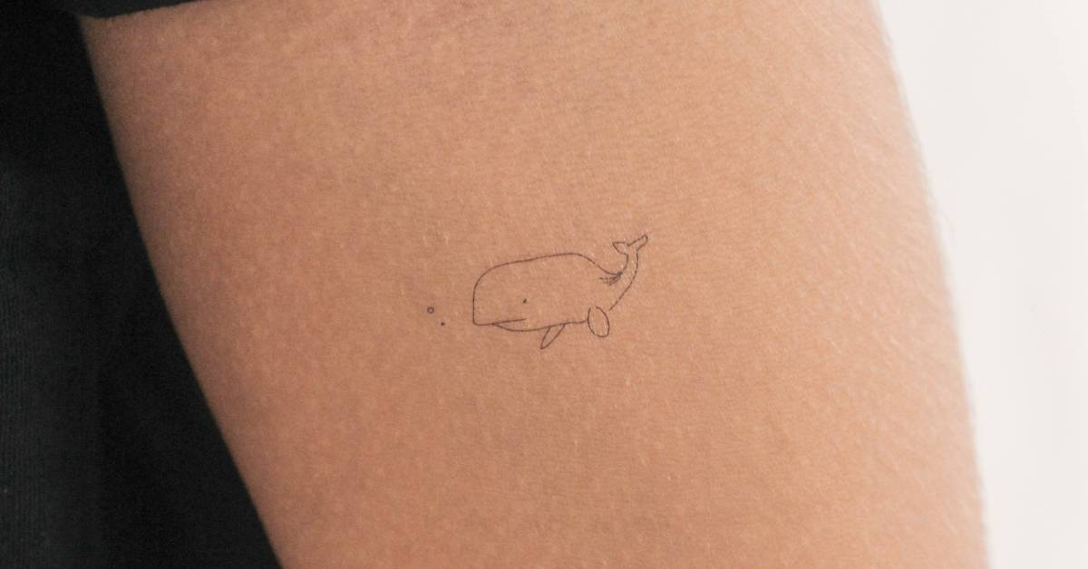 Minimalist fine line whale temporary tattoo located on