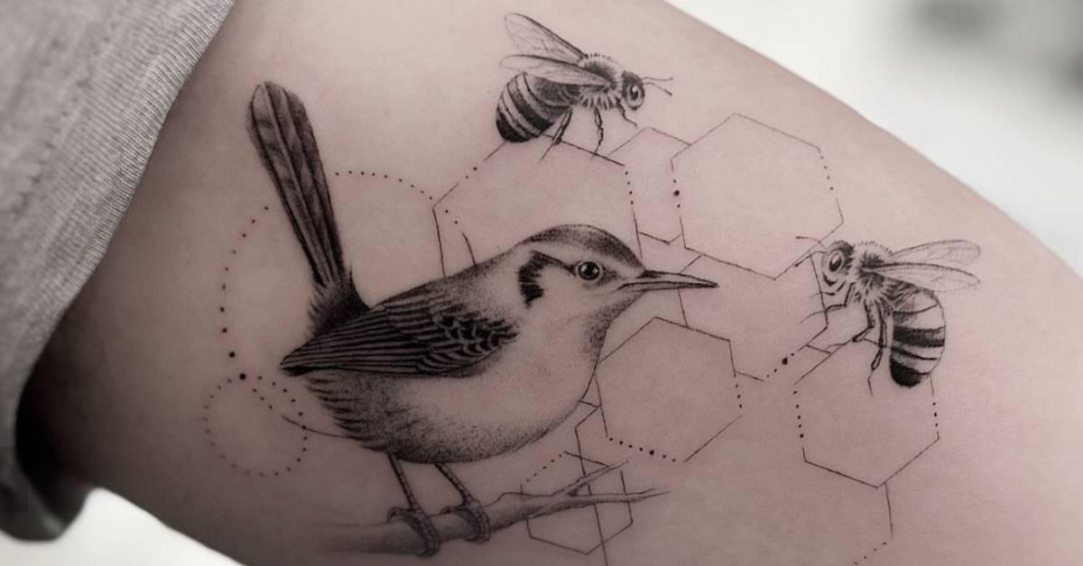 Wren bird and bees tattoo located on the inner arm,