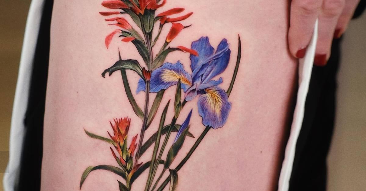 Indian paintbrush and iris tattoo located on the thigh,