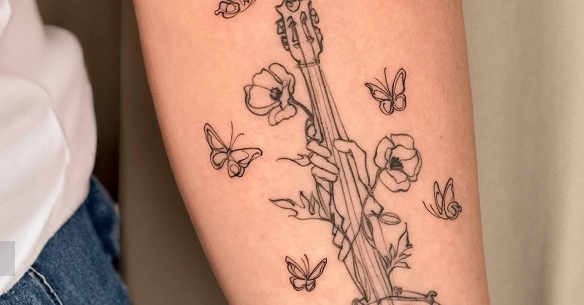 Banjo, flowers and butterflies tattoo located on the