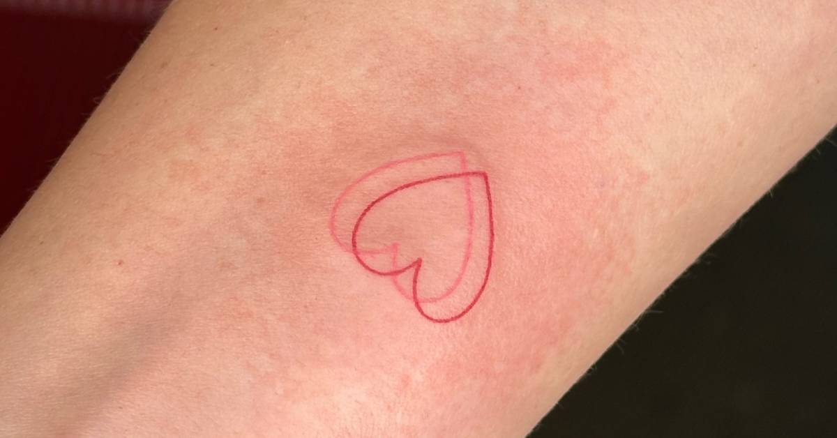Red heart tattoo in minimalistic style placed on the