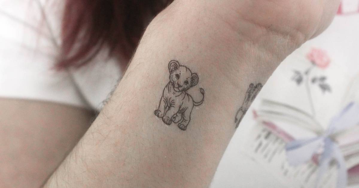 Little fine line lion cub temporary tattoo located on