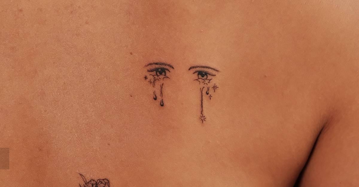 Crying eyes and still life tattoos located on the back.