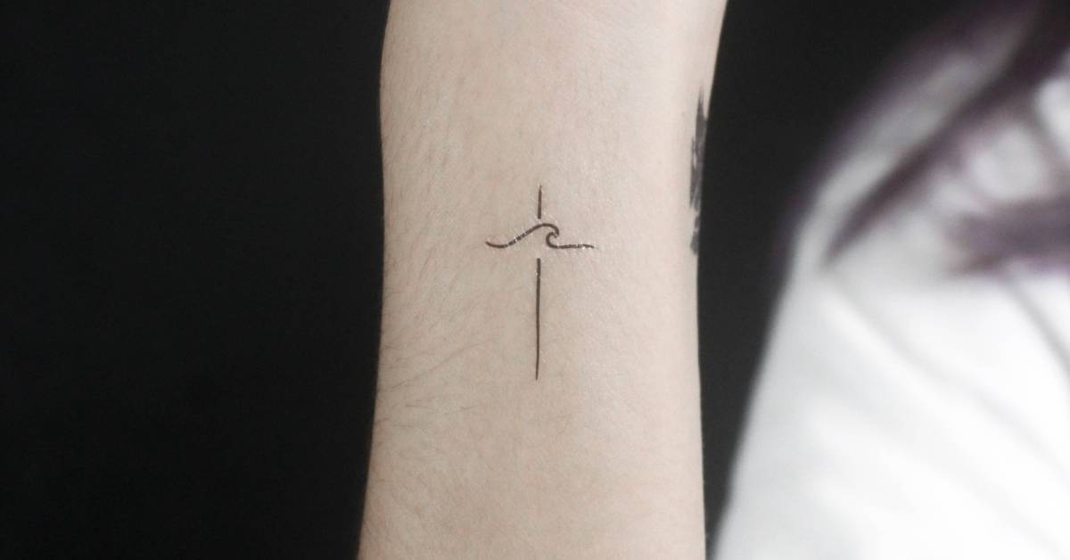 Small minimalistic wave cross temporary tattoo located