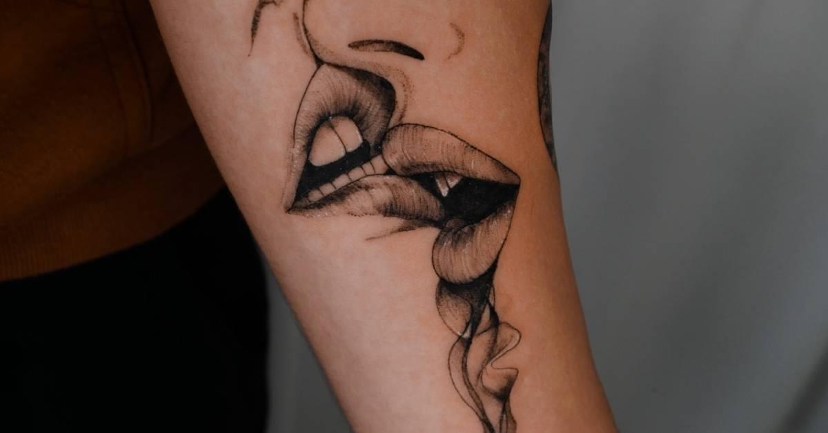 Illustrative style kiss tattoo located on the wrist.