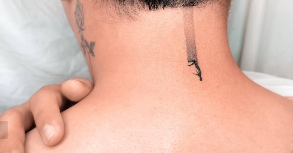 Person falling tattoo located on the back of the neck.
