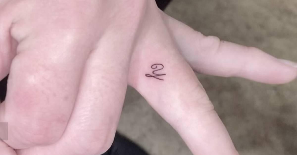 Tiny letter "Y" tattoo placed on the finger.