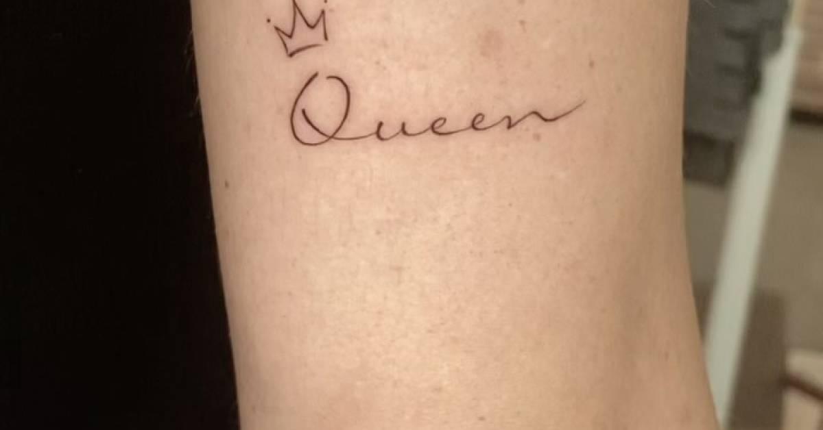 Handwritten lettering tattoo of the word "queen" placed