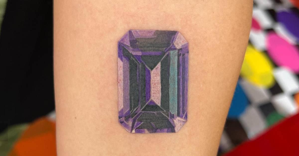 Amethyst gem tattoo located on the inner forearm.