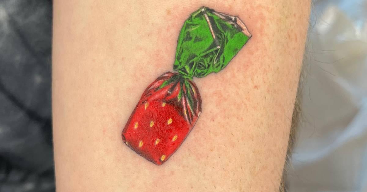 Strawberry candy tattoo located on the inner forearm.