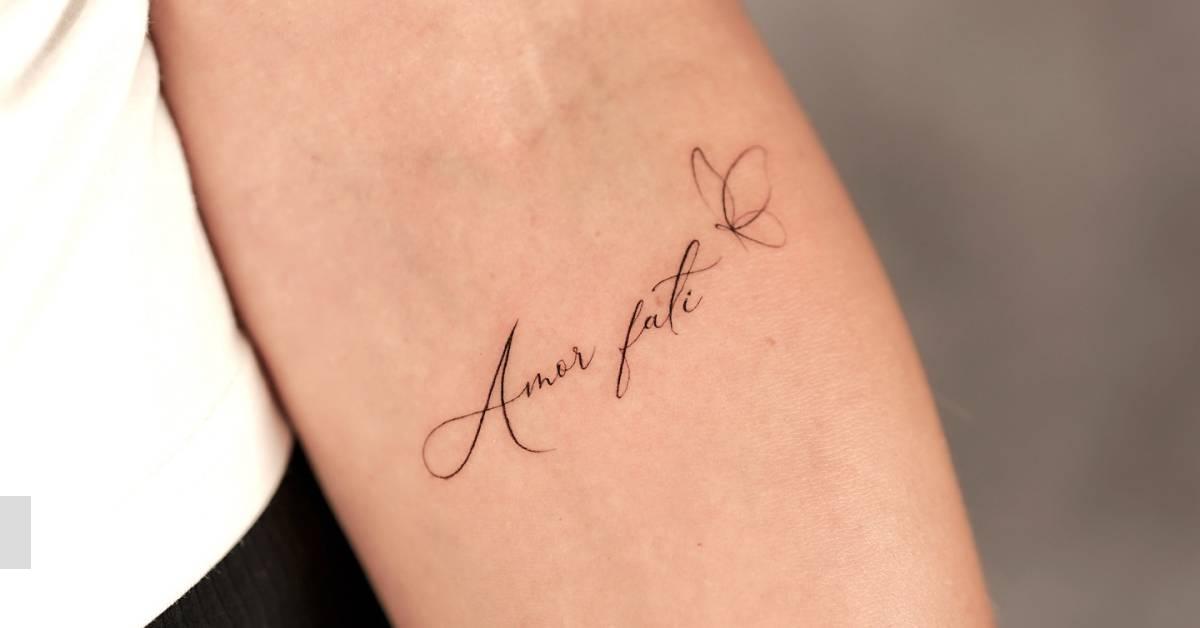 "Amor fati" and butterfly tattoo located on the inner