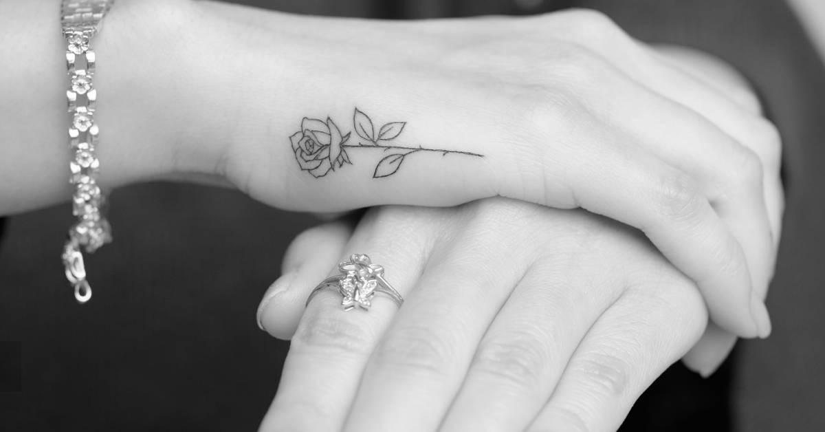 Fine line style rose tattoo located on the hand.
