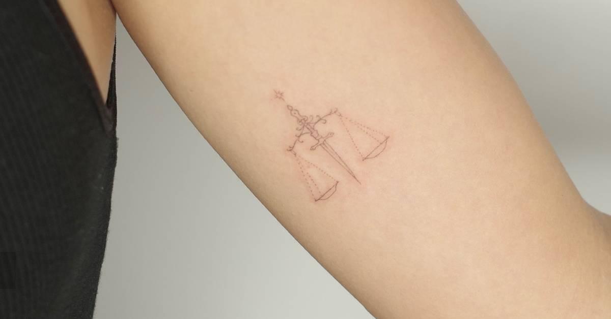 Scale and dagger tattoo located on the inner arm, done