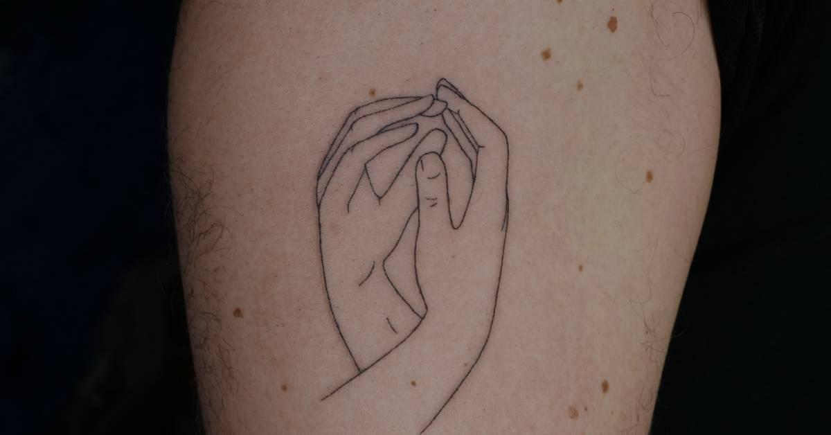 Holding hands tattoo in line art style placed on the