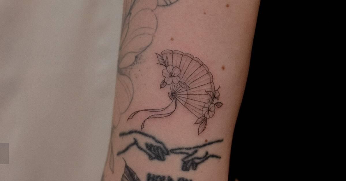 Hand fan tattoo in fine line style located on the