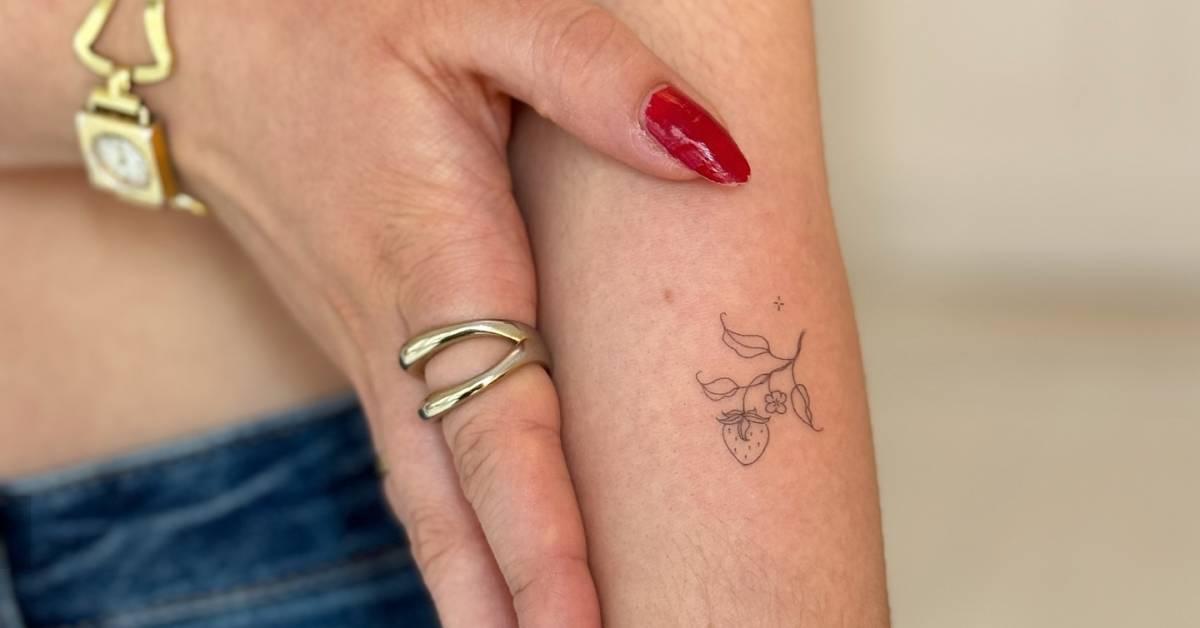 Strawberries tattoo in fine line style placed on the