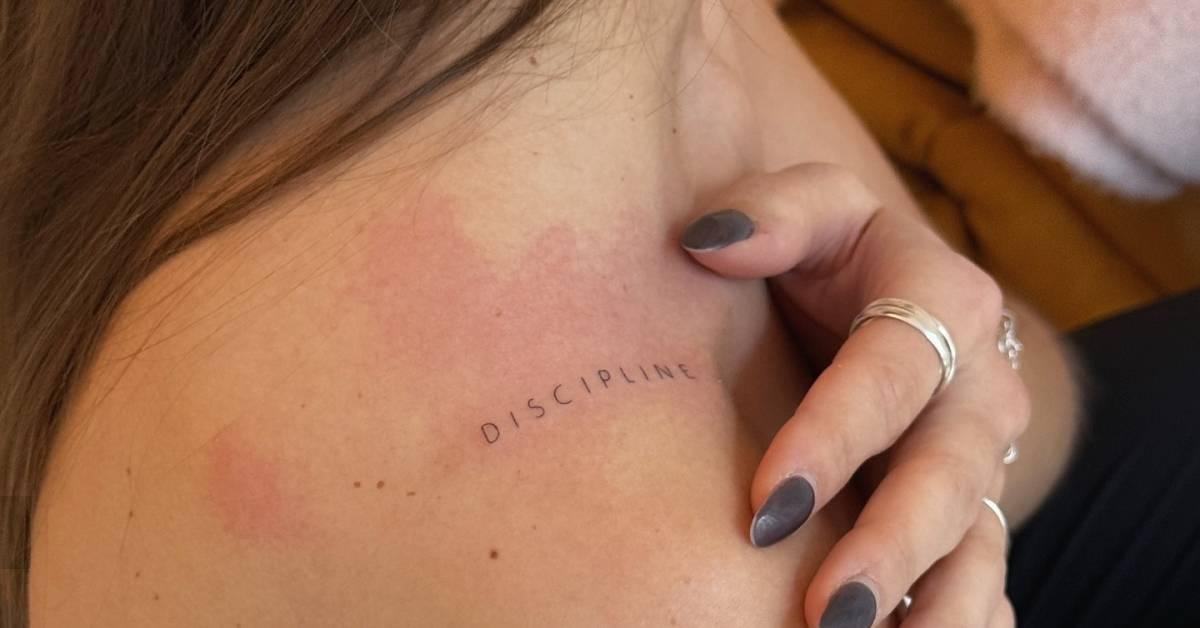 "Discipline" handwritten lettering tattoo placed on the
