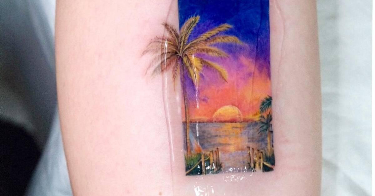Watercolor style beach sunset tattoo located on the