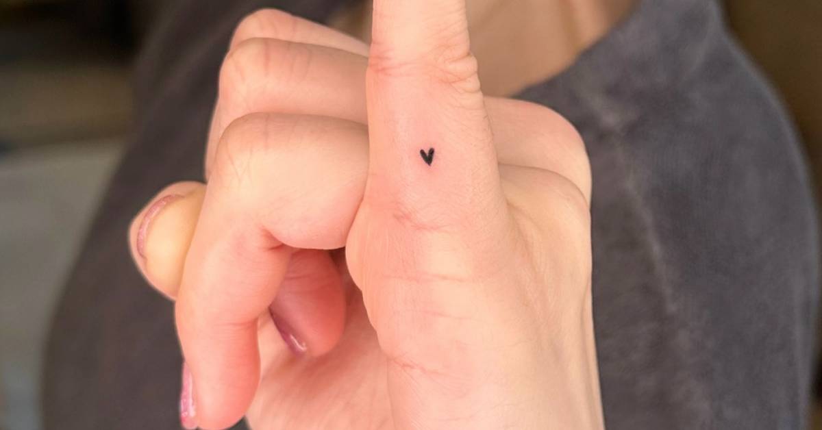 Tiny minimalistic heart tattoo placed on the finger.