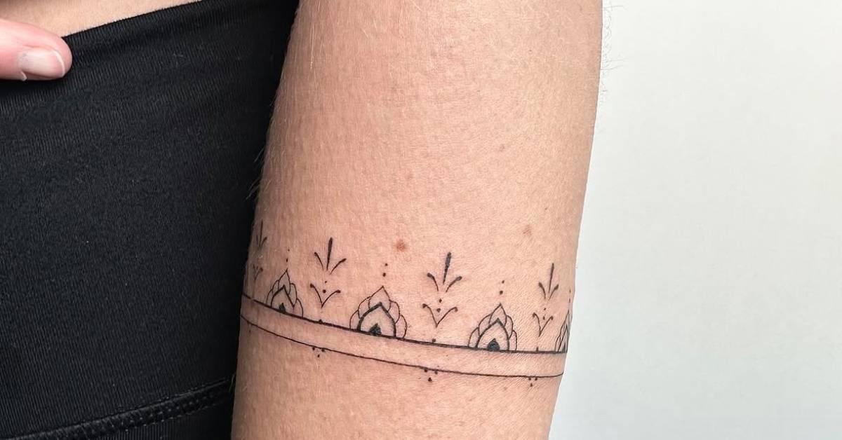 Ornamental armband tattoo in fine line style.