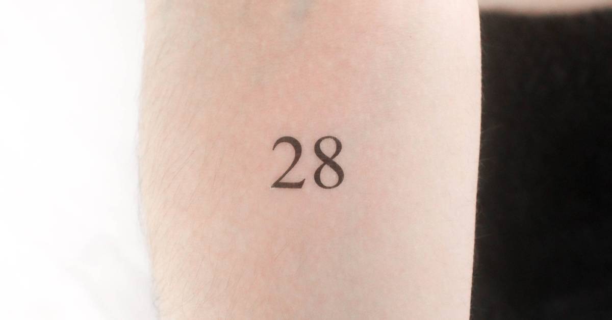 Temporary lettering tattoo of the number "28" located