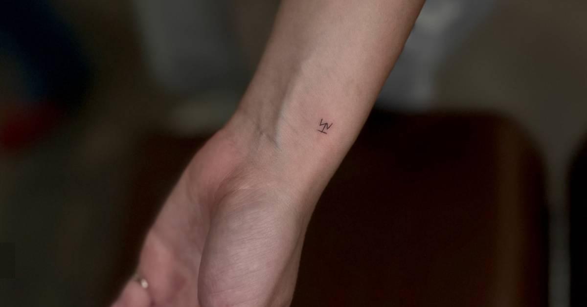 Initials "TM" tattooed on the wrist, minimalistic