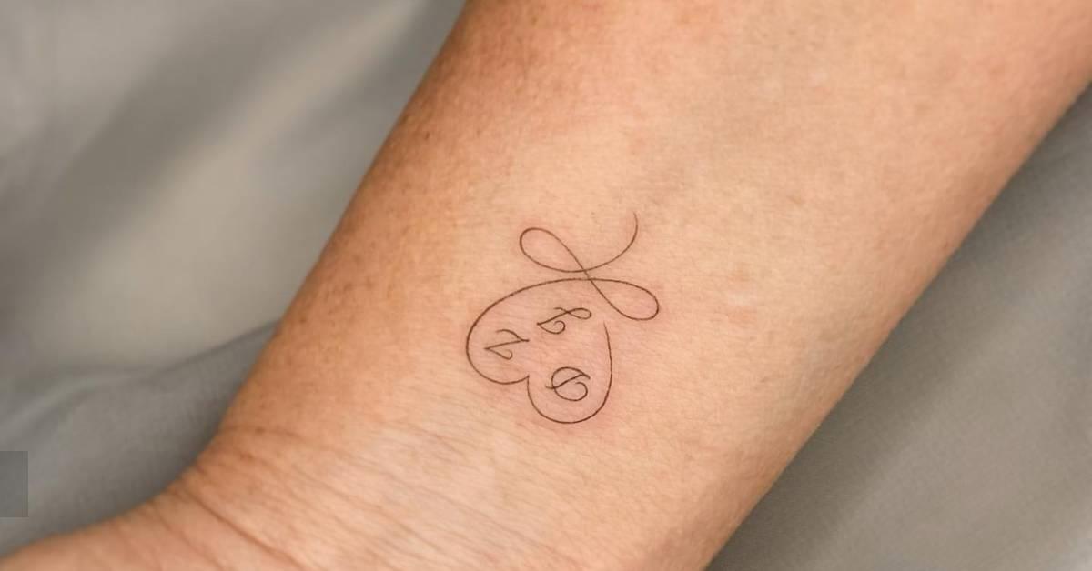 Fine line style heart and initials tattoo located on