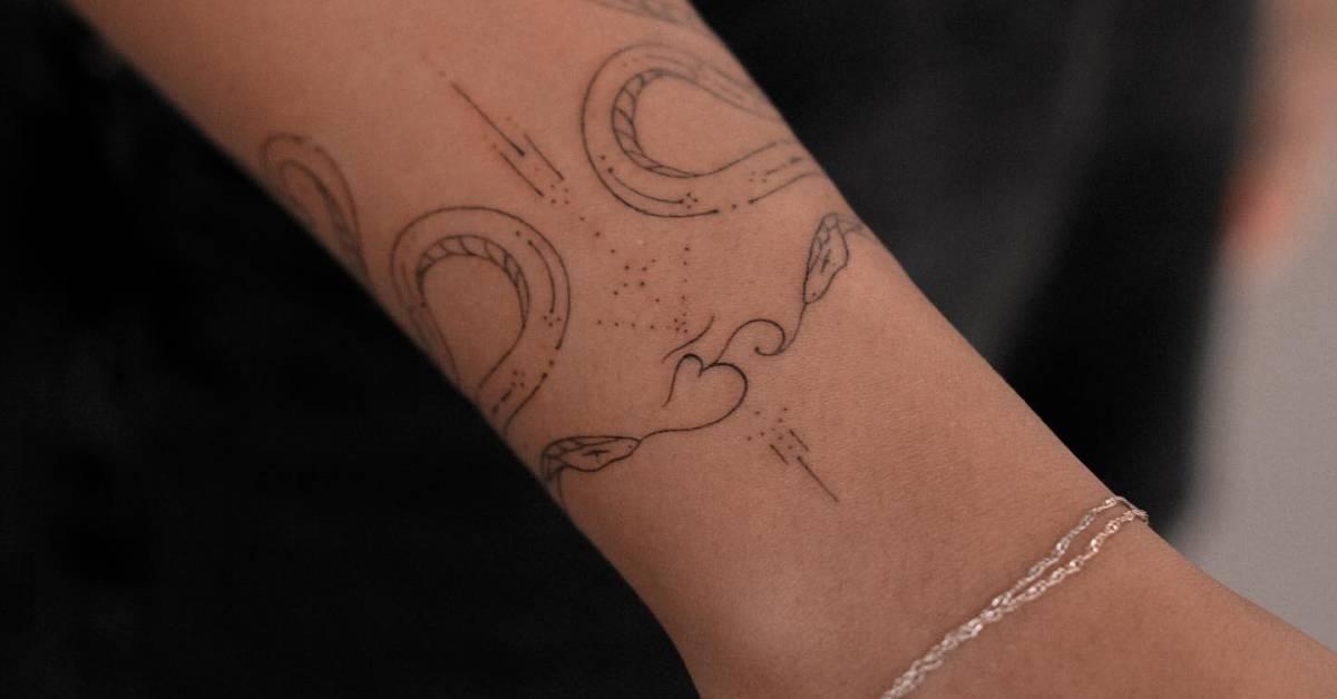 Hand poked snake bracelet tattoo located on the wrist.