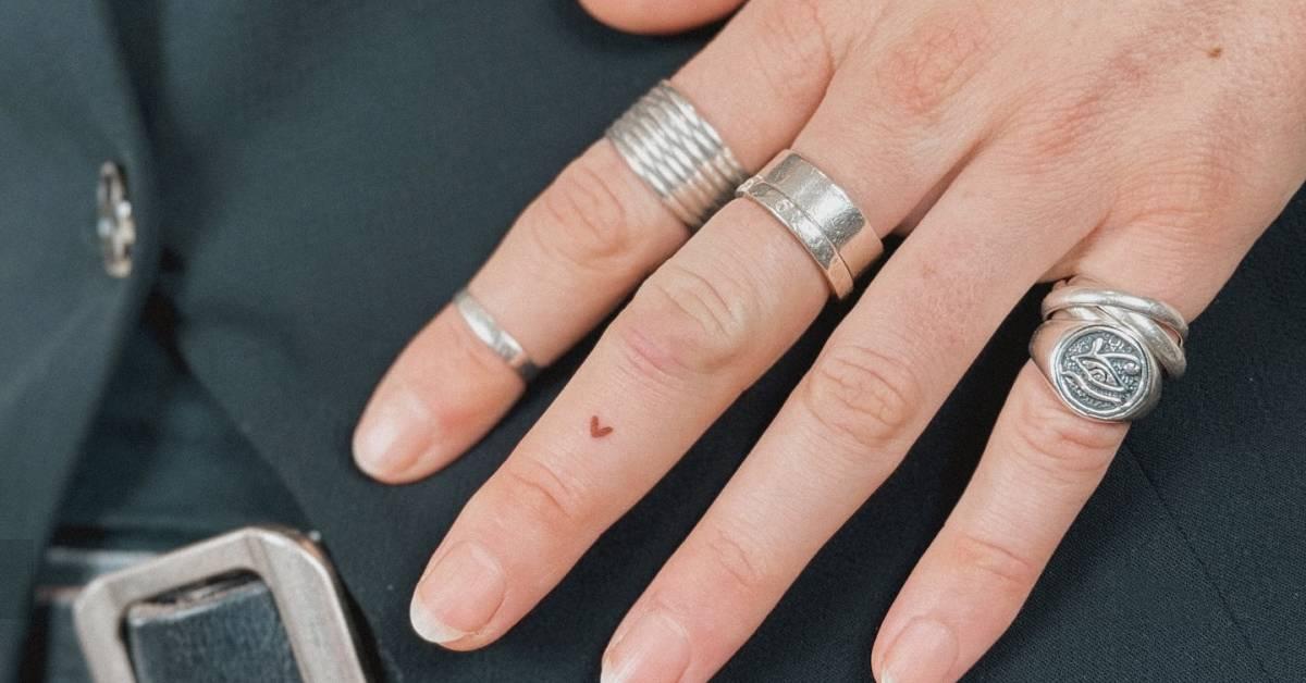 Micro minimalistic red heart tattoo done on the finger.