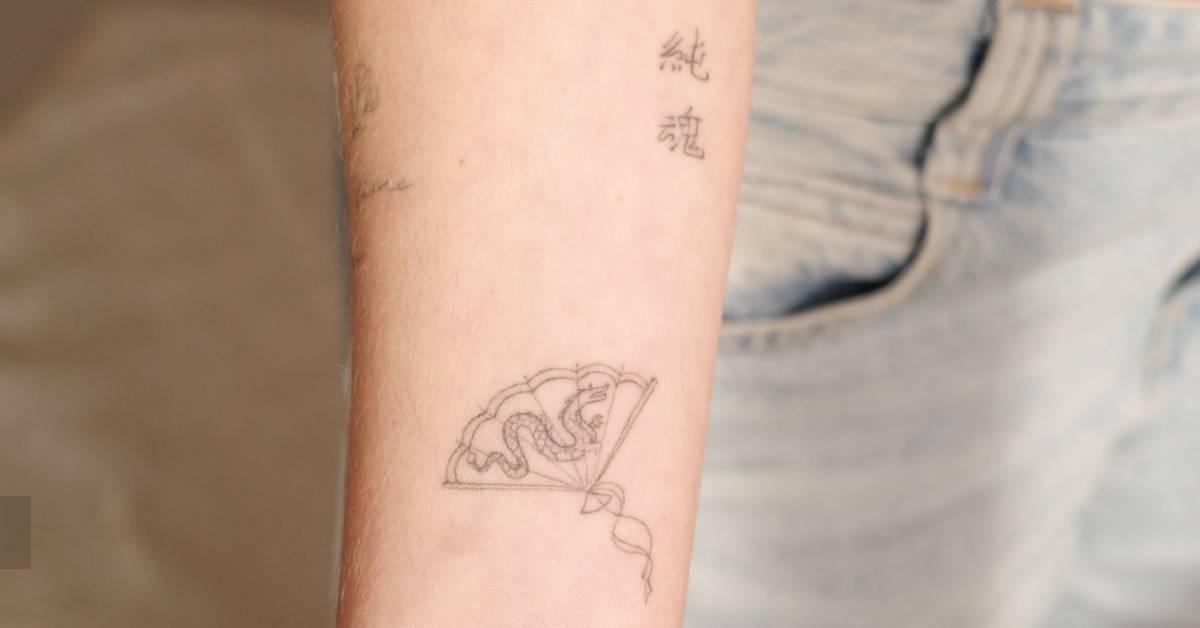 Healed fine line style hand fan tattoo located on the