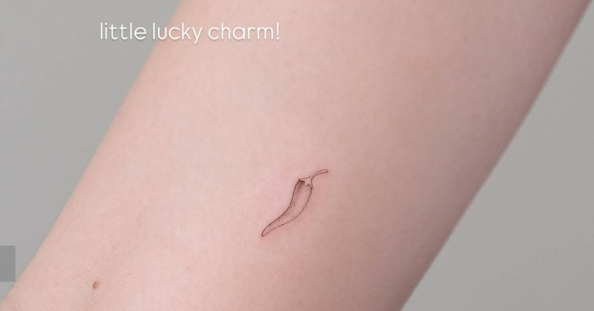 Little chilli pepper tattoo located on the inner arm.