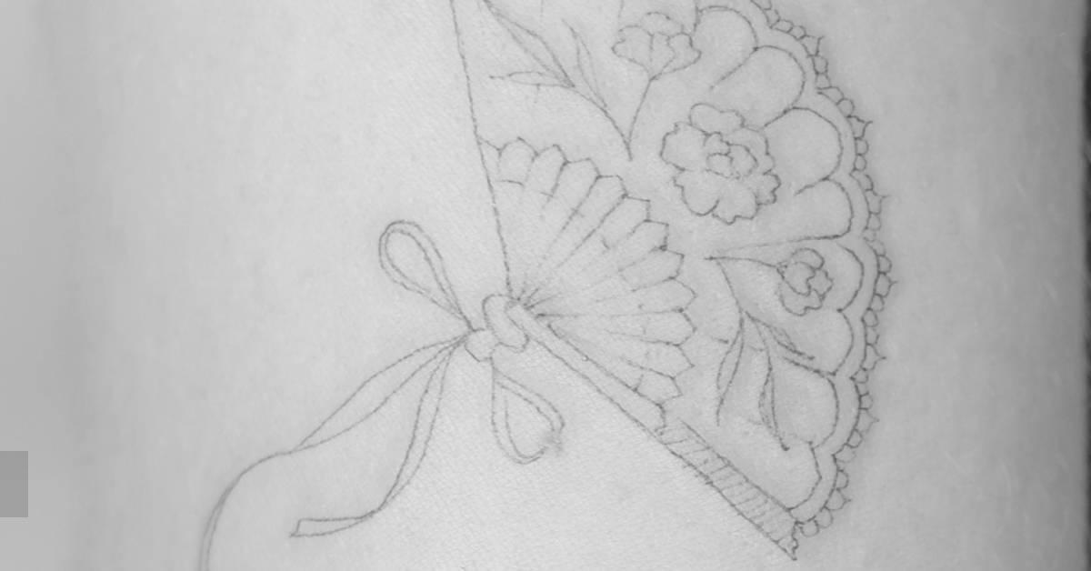 Hand fan tattoo in fine line style placed on the upper
