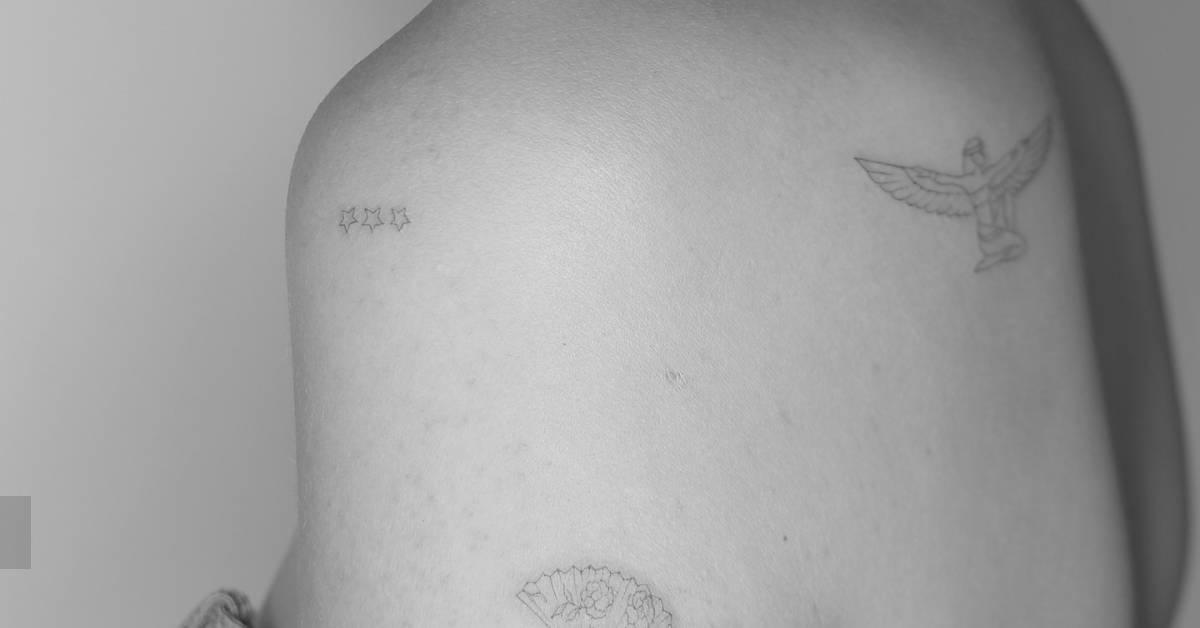 Hand fan tattoo in fine line style placed on the upper