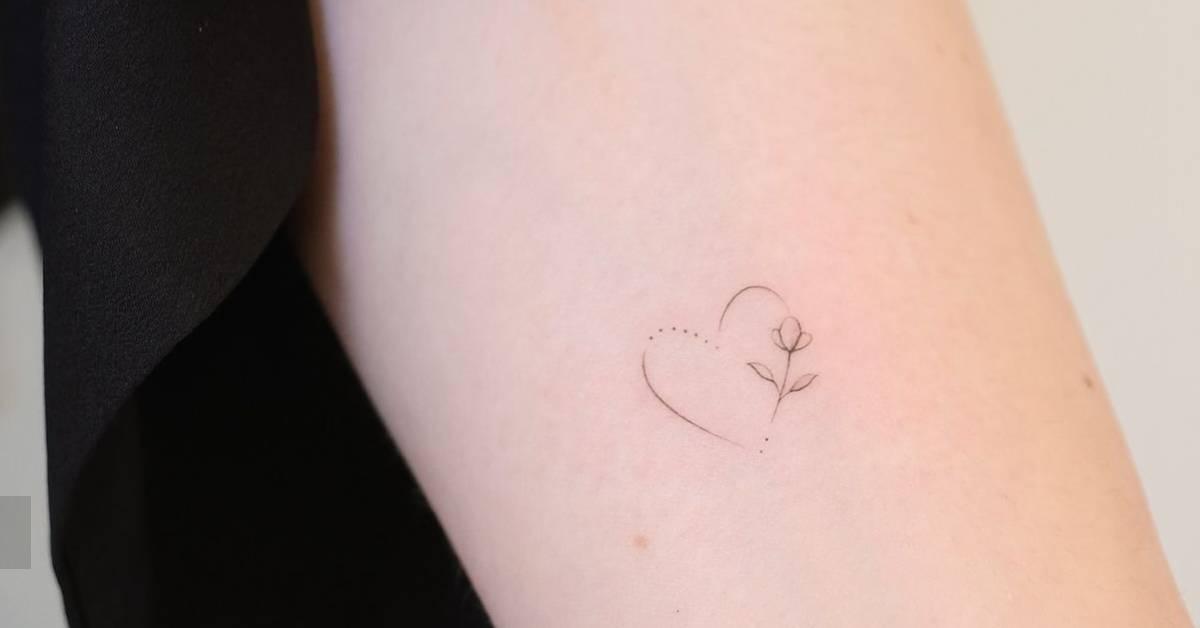 Fine line style flower and heart tattoo placed on the