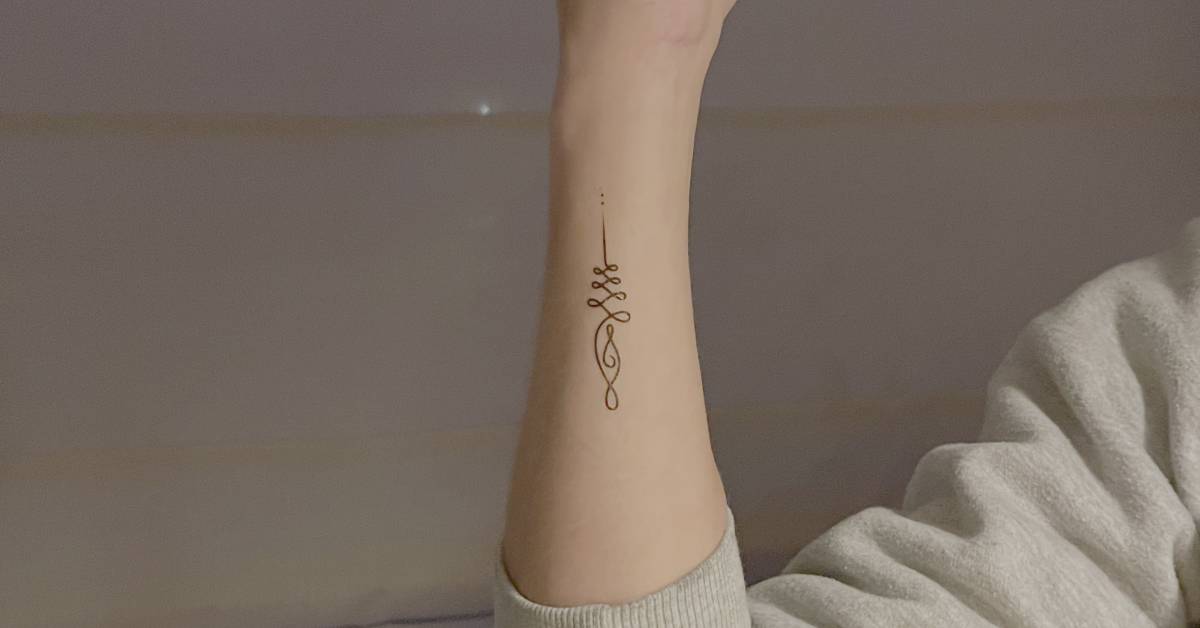Fine line style unalome temporary tattoo locater on the