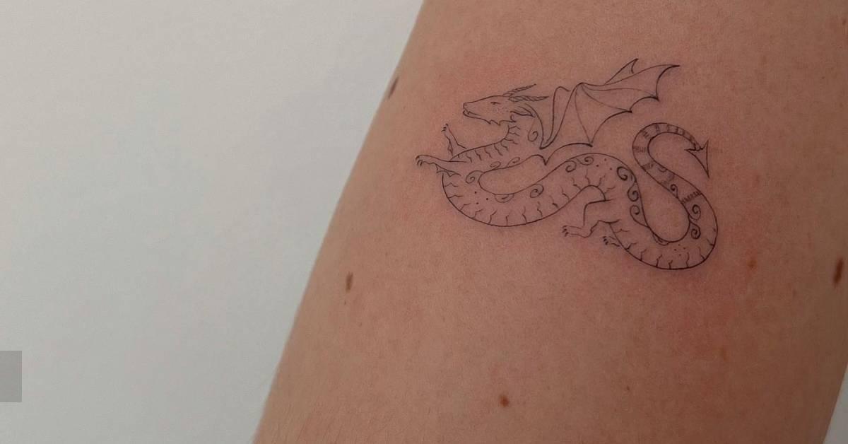 Fine line dragon tattoo located on the upper arm.