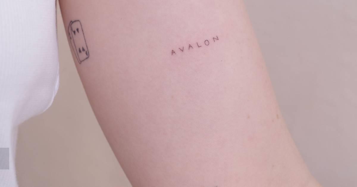 "Avalon" handwritten lettering tattoo placed on the